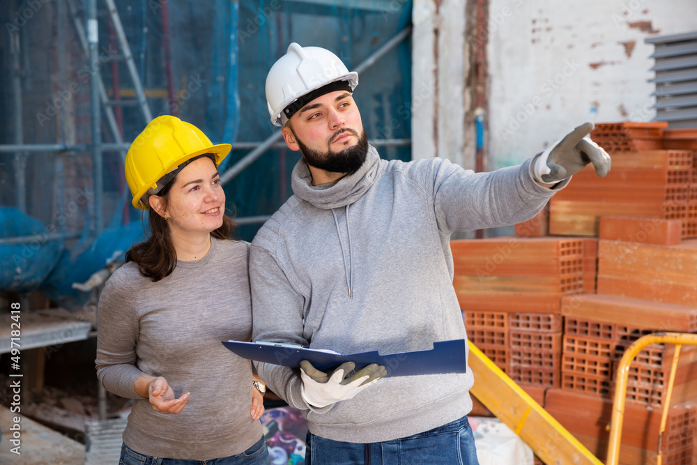 Civil engineers inspecting process of building overhaul, comparing to ...