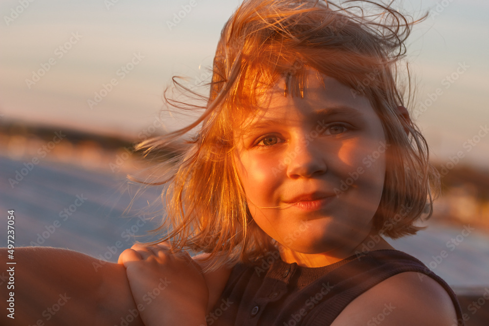Portrait of a happy tanned child at the sea. A young girl of ten years ...