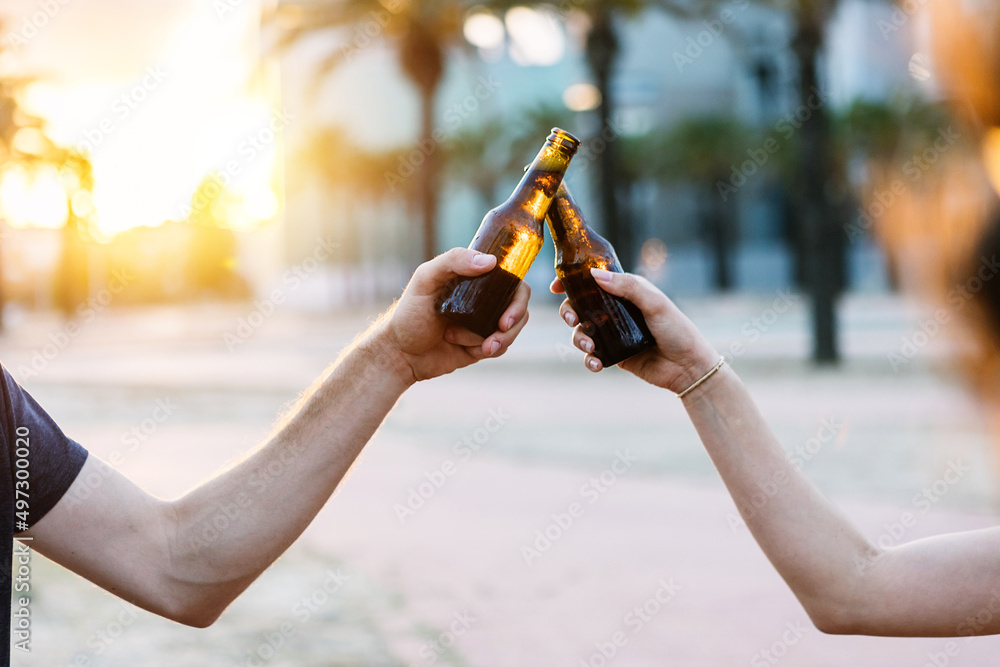 Two young people celebrating with beer - Unrecognizable teenagers ...
