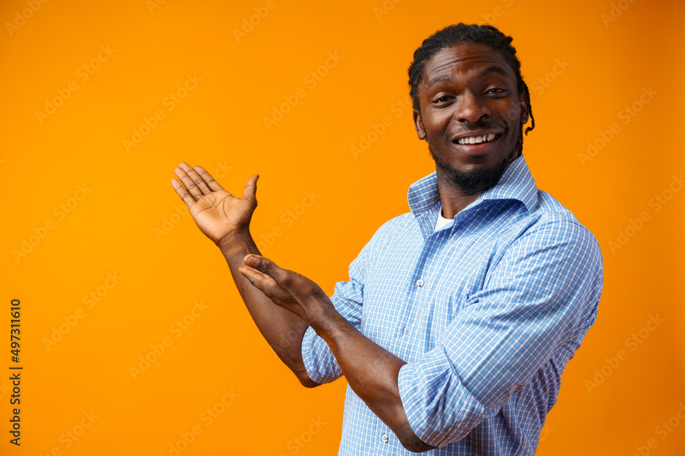 Young african american man pointing at copy space over yellow ...