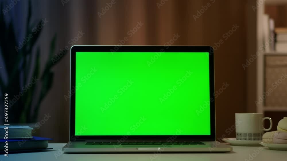 Modern laptop with mock up chroma key green screen on desk of living ...