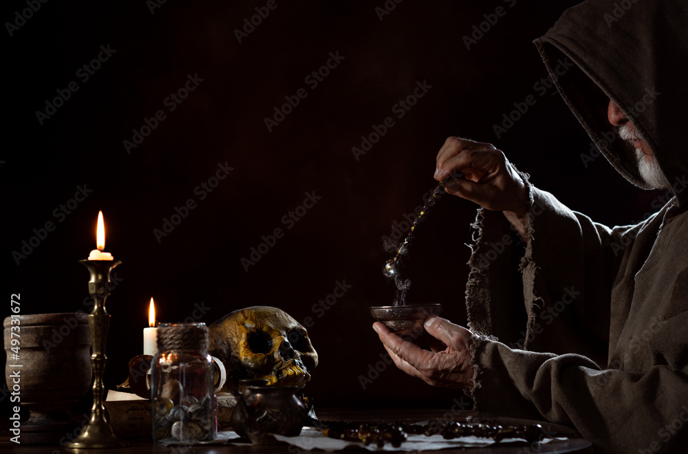 Medieval magician with magic wand mixing elixir Stock Photo | Adobe Stock