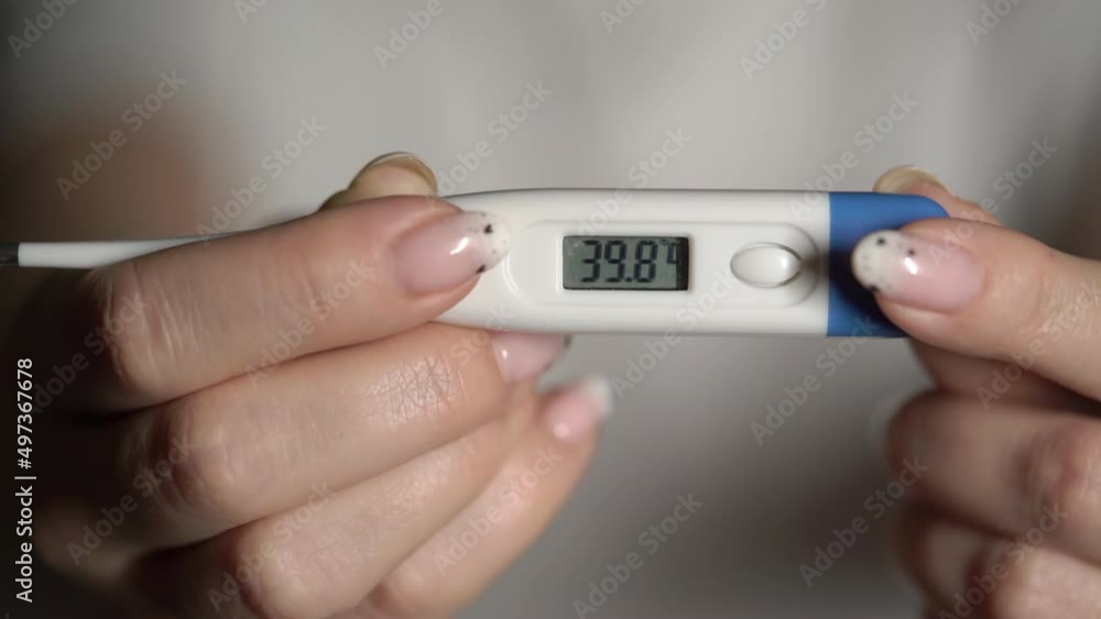 Woman holds thermometer in hands to measure body temperature. 36 ...