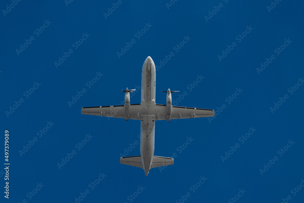 Underside view of modern twin propeller engine descending from the ...