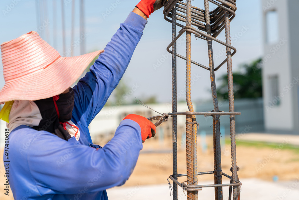 Workers use pliers to tie wires to rebar to pour concrete columns Stock ...