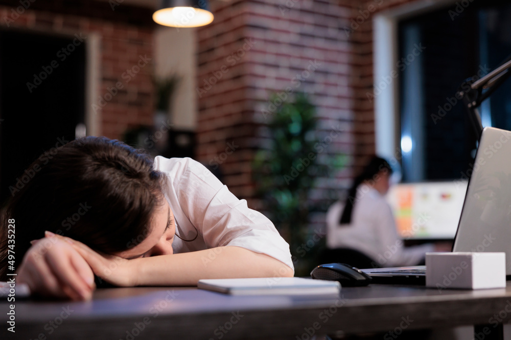 Fatigued marketing agency employee sleeping on desk because of overtime ...