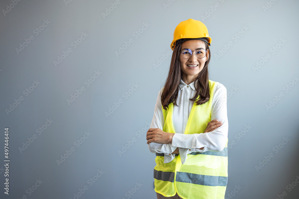 Beautiful asian woman engineer and safety helmet on gray background ...