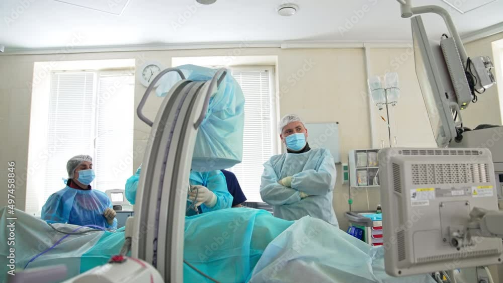 Surgeons operating the patient in modern clinic. Doctors team look ...
