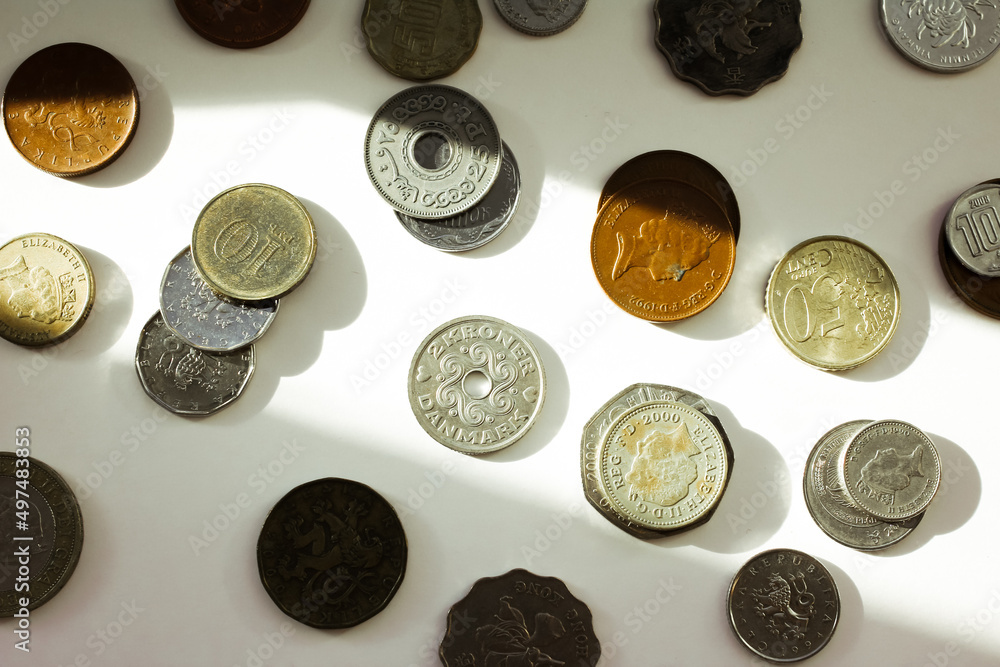 coins of different countries laid out on the surface in rows and ...