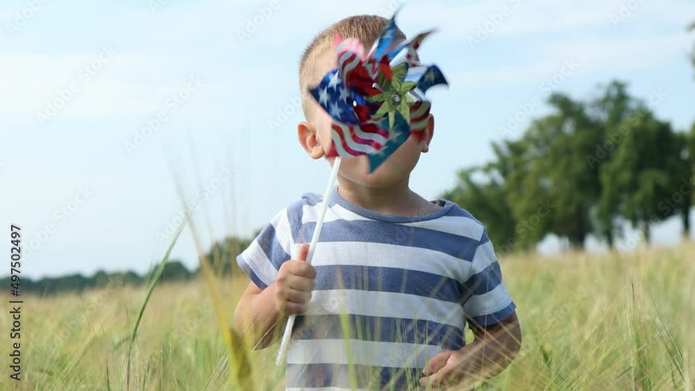 child boy kid playing with windmill pinwheel outdoors in green wheat ...