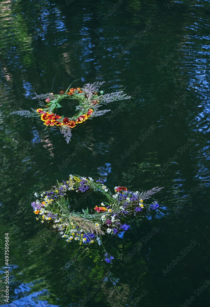floral wreaths in dark water. old national tradition, fortune telling ...