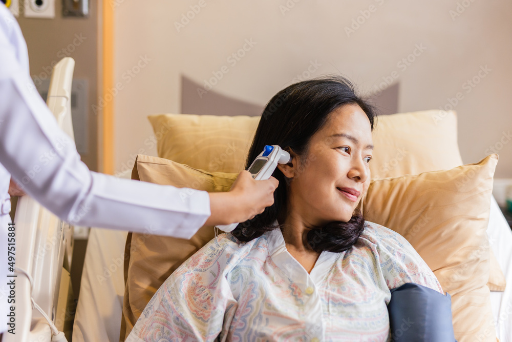 Nurse checking patient's temperature in the ear with Tympanic ...