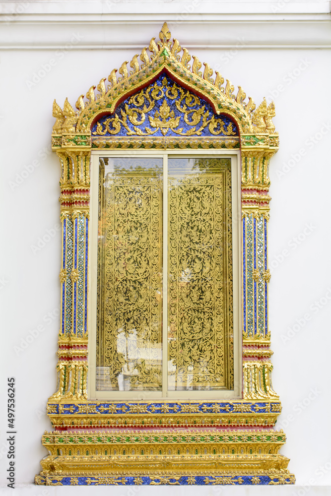 Foto de Vertical shot of ancient golden temple windows on a white wall ...