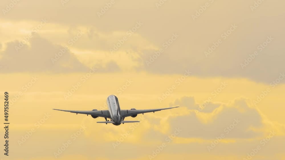 Jet plane take off and climb over the city at sunset. Rear view ...