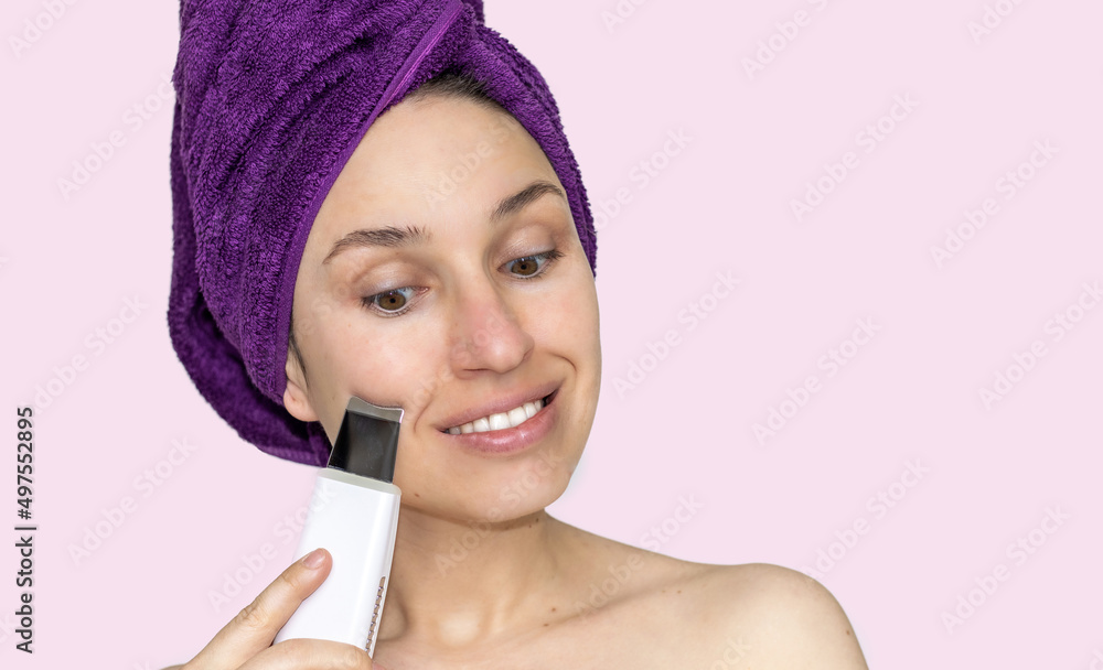 ultrasonic face cleaning concept. excited woman with purple towel on ...