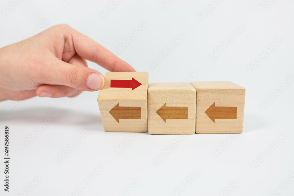 Hand flip over wooden cube block with red arrow facing the opposite ...