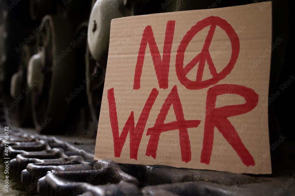 "No War" placard with peace sign on army tank caterpillar continuous ...