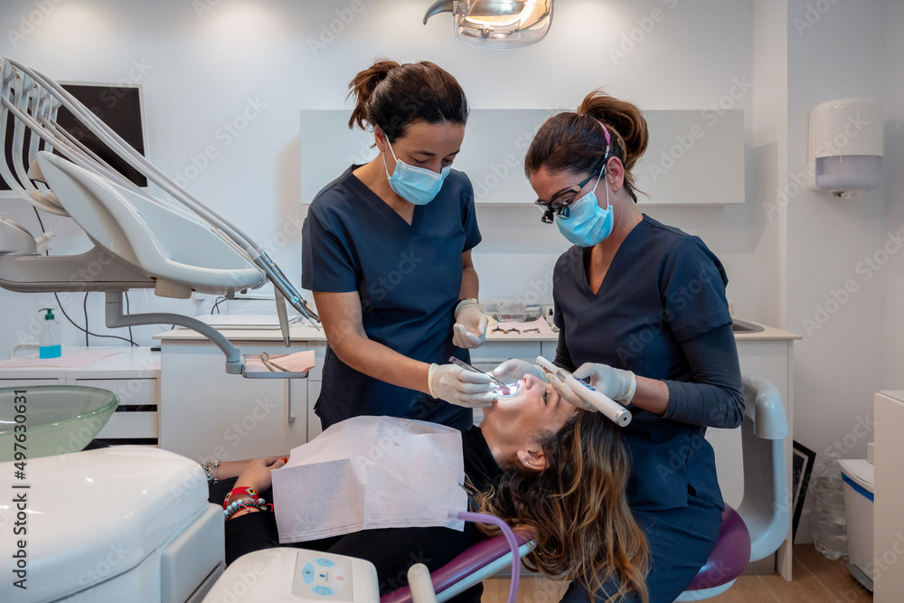 Professional dentists treating teeth of female patient Stock Photo ...