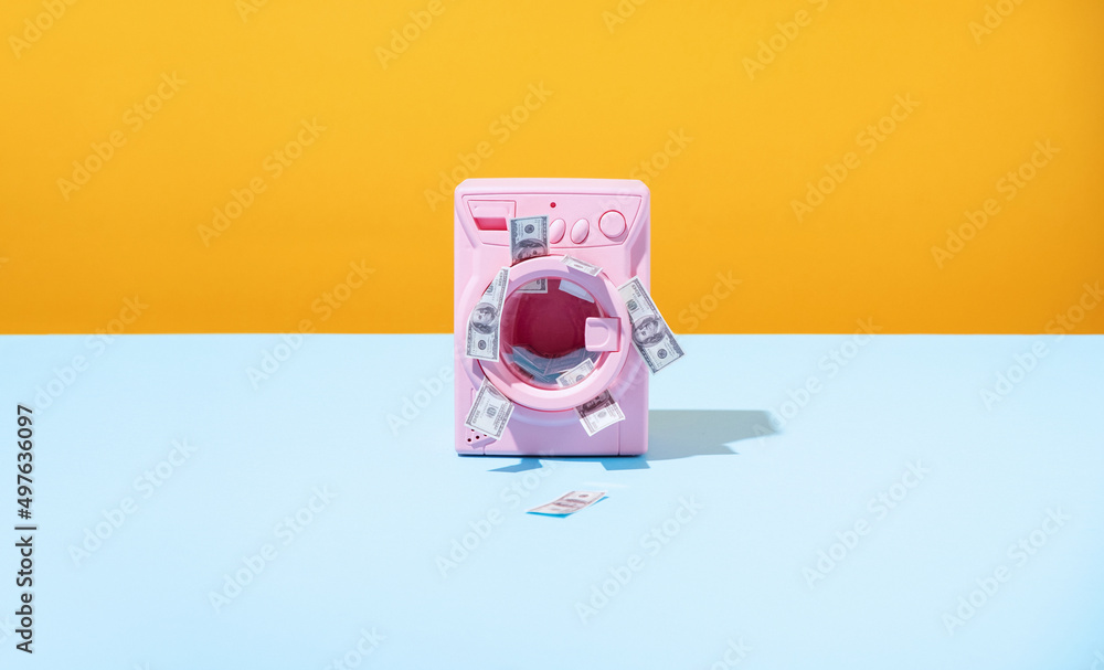 Washing machine washing dollar bills. Stock Photo | Adobe Stock