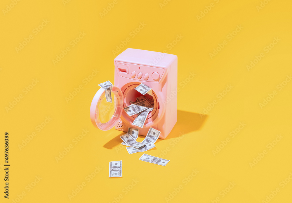 Washing machine washing dollar bills. Stock Photo | Adobe Stock