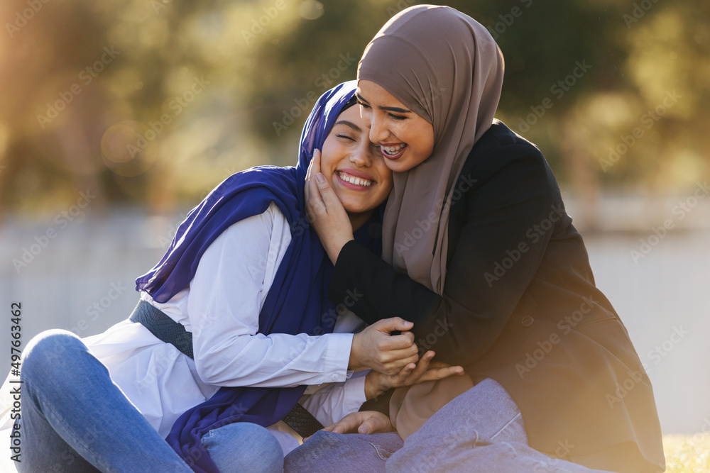 Happy Muslim women in hijab hugging and caressing a friend Stock Photo ...
