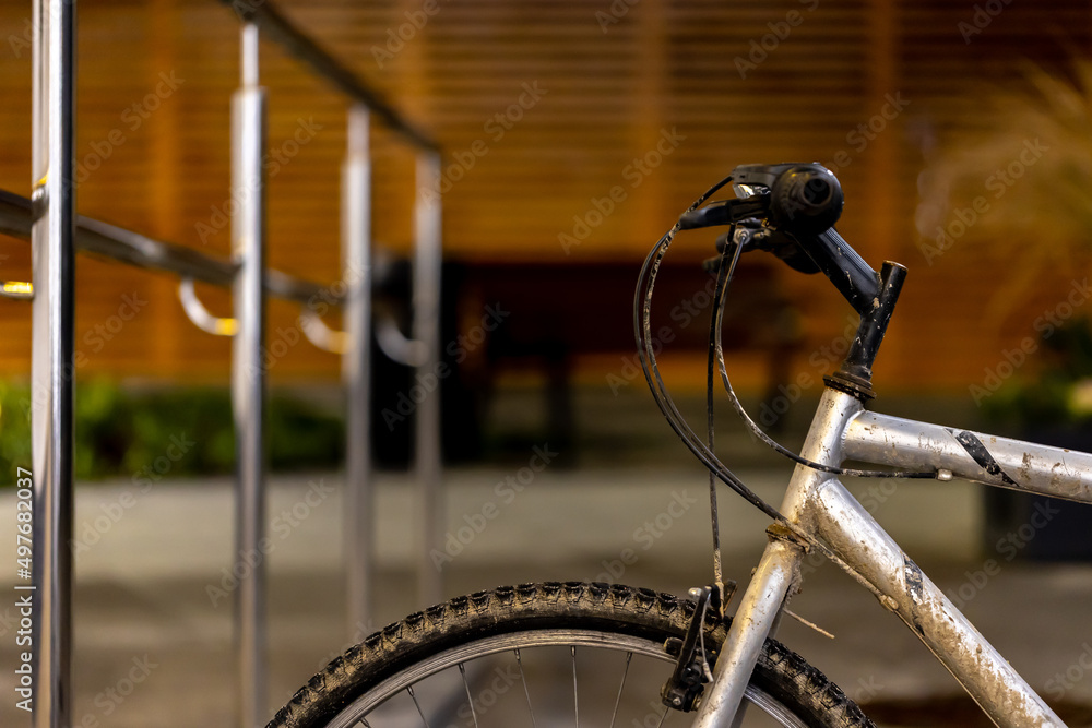 Old and dirty mountain bike used for commuting parked in the bike rack ...