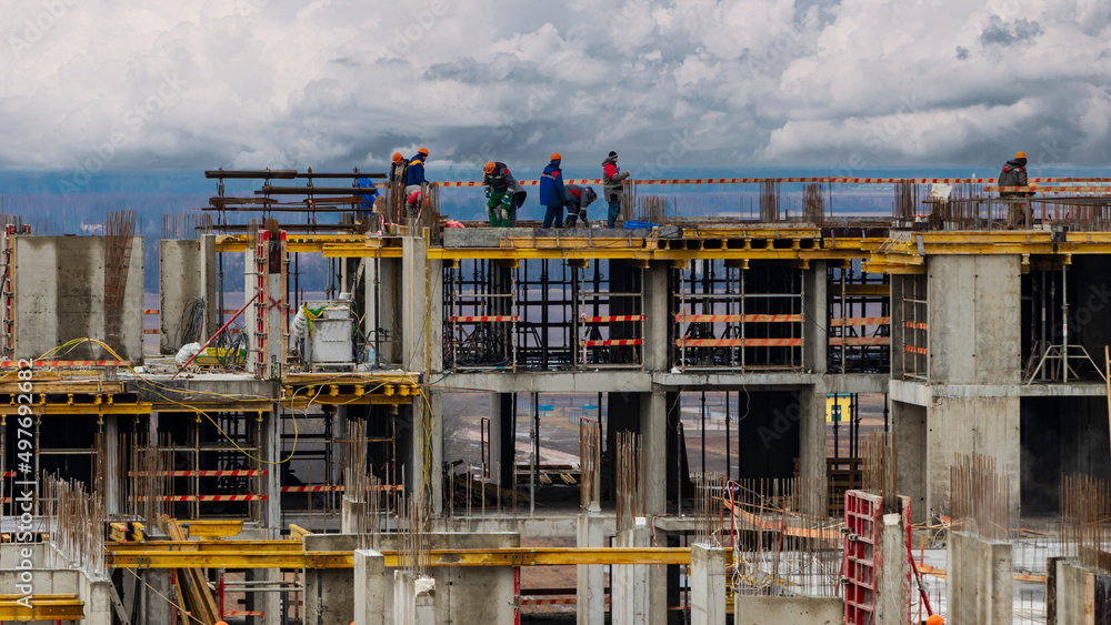 Monolithic frame construction of the building. Workers working at the ...