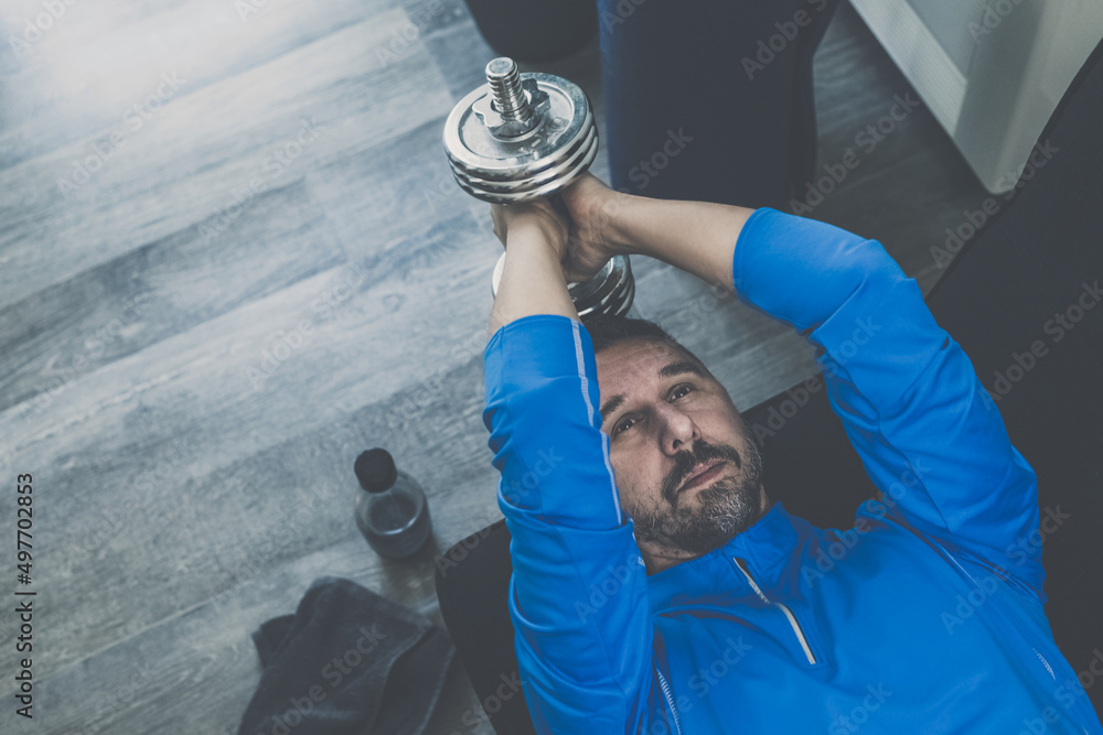 Determined sporty young man working out and trains at home. Fit male ...