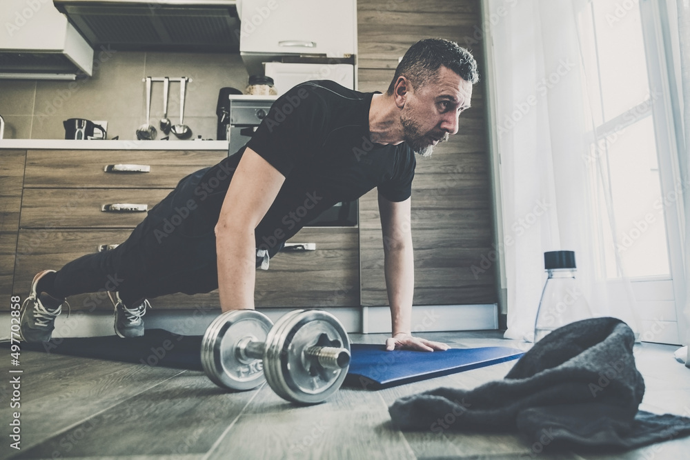 Determined sporty young man working out and trains at home. Fit boy ...