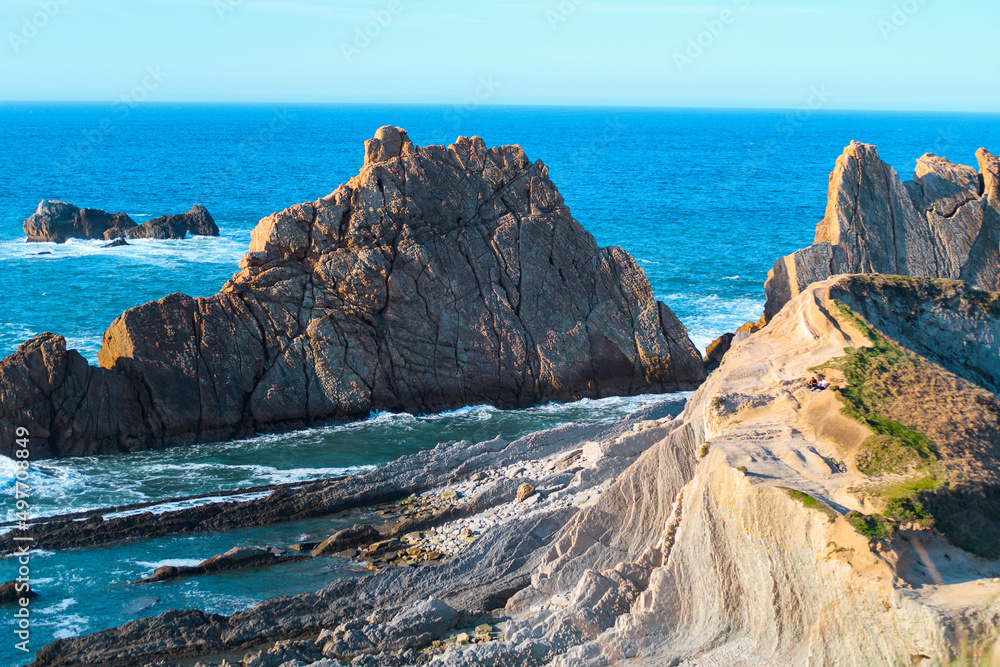 Descubriendo Cantabria. Paisaje de costa con dos personas caminando en ...