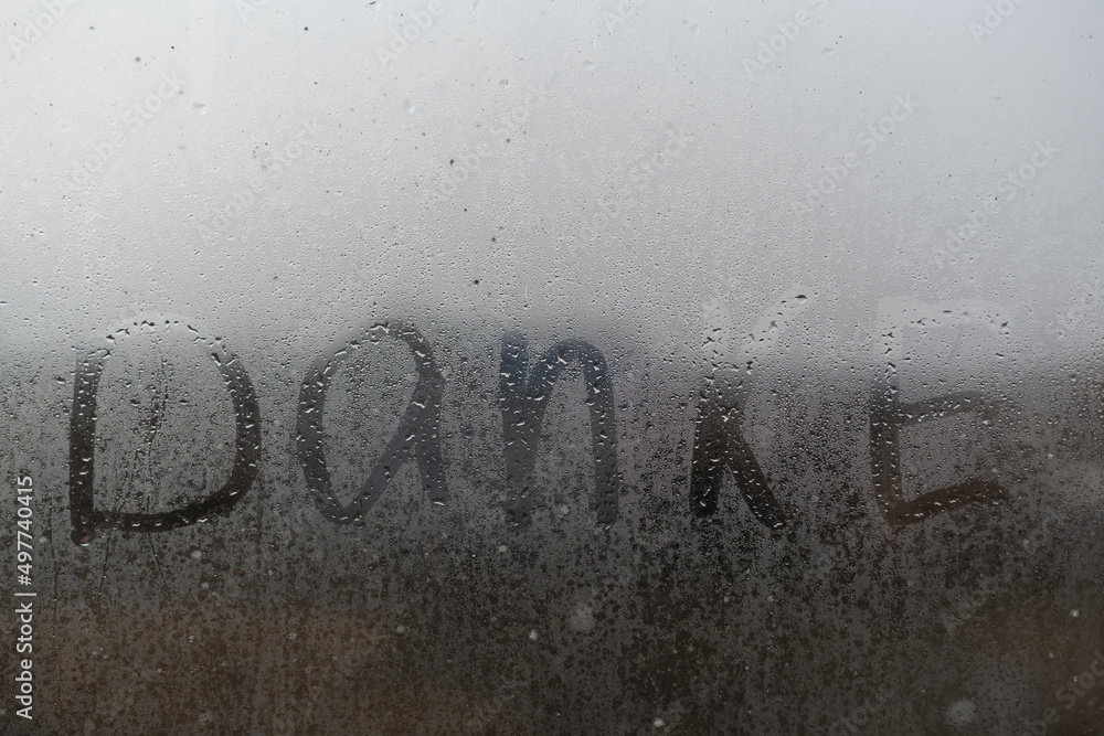 Handwritten lettering thanks in german Danke on misted rainy glass on ...