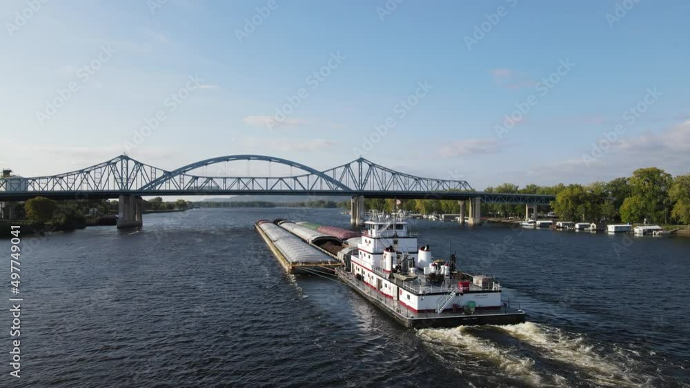 Tug boat pushing full barges under the big blue bridges and down the ...