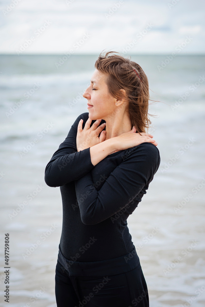 Relaxed woman on the beach in black danger Stock Photo | Adobe Stock