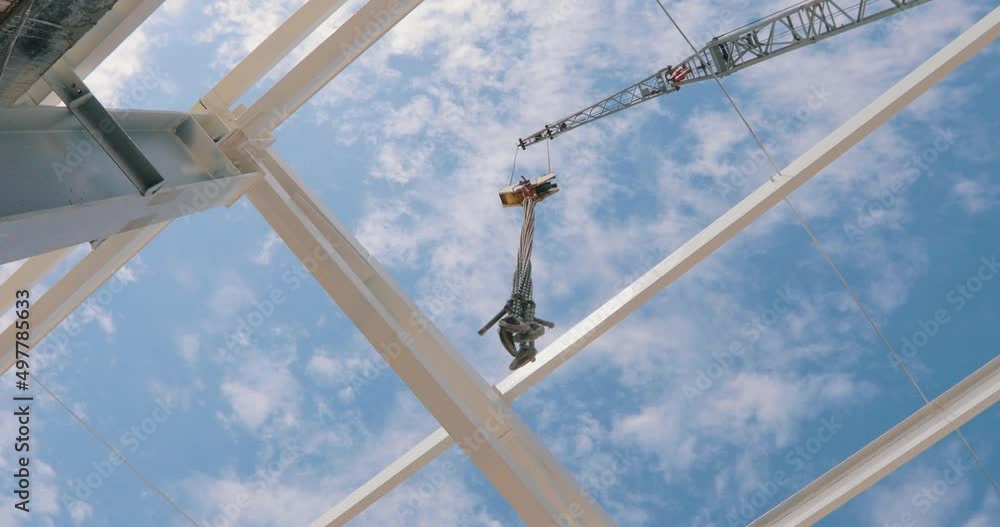Construction crane on a background of blue sky with clouds. Bottom view ...