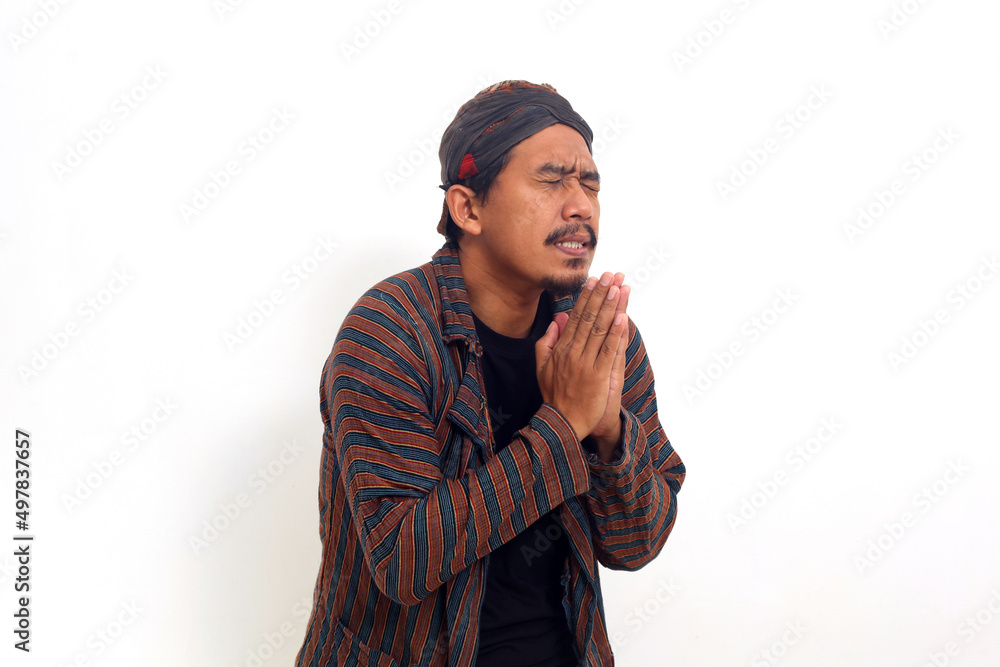Sad asian man in java traditional costume begging for forgiveness ...