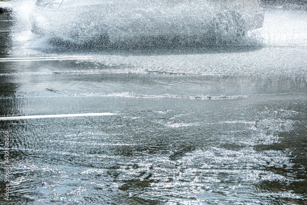 rainwater splashing from wheels of car in motion on flooded road Stock ...