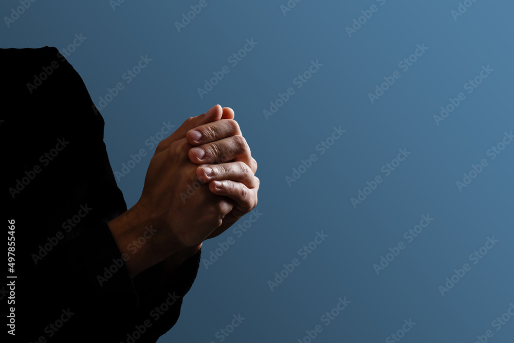 Praying hands with faith in religion and belief in God on dark ...