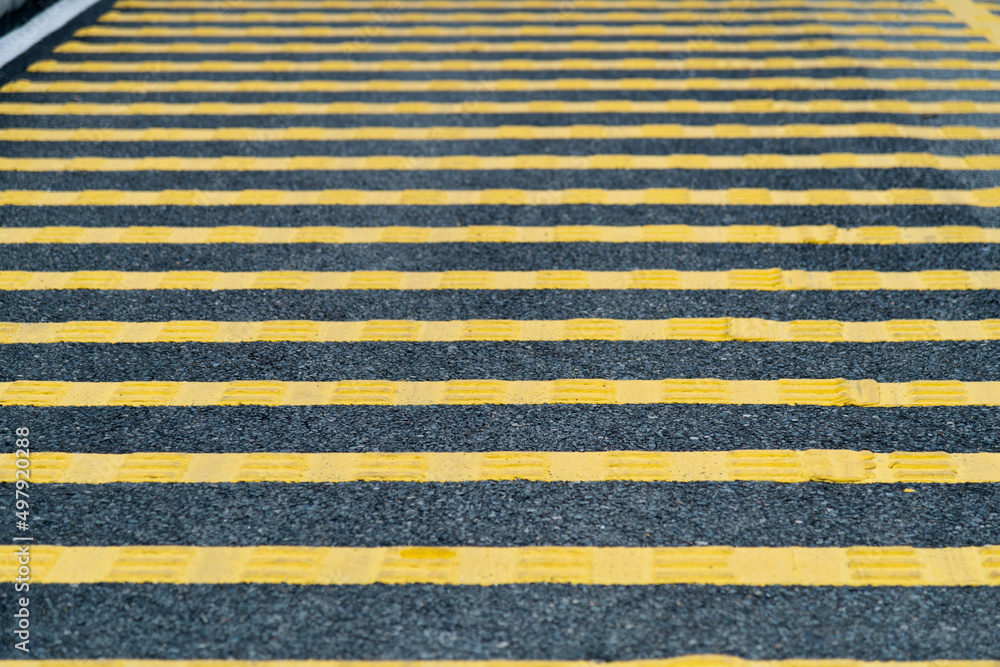 Yellow speed bump on asphalt road Stock Photo | Adobe Stock