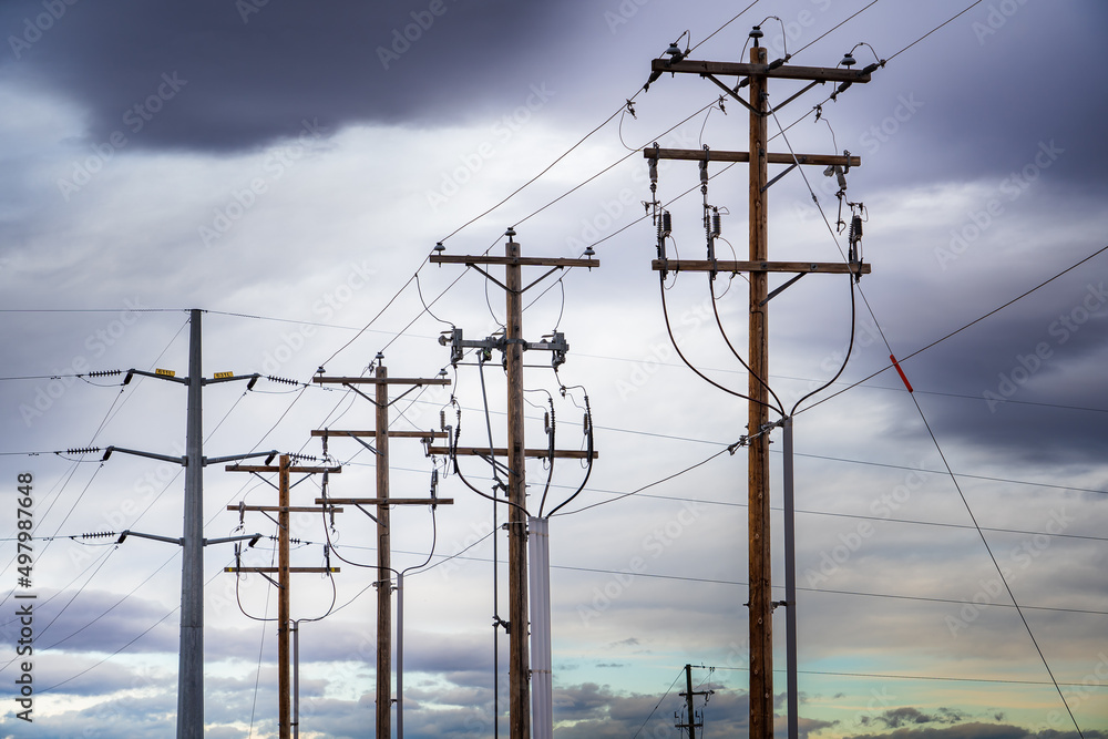 Power lines hang from wooden power poles and steel transmission towers ...