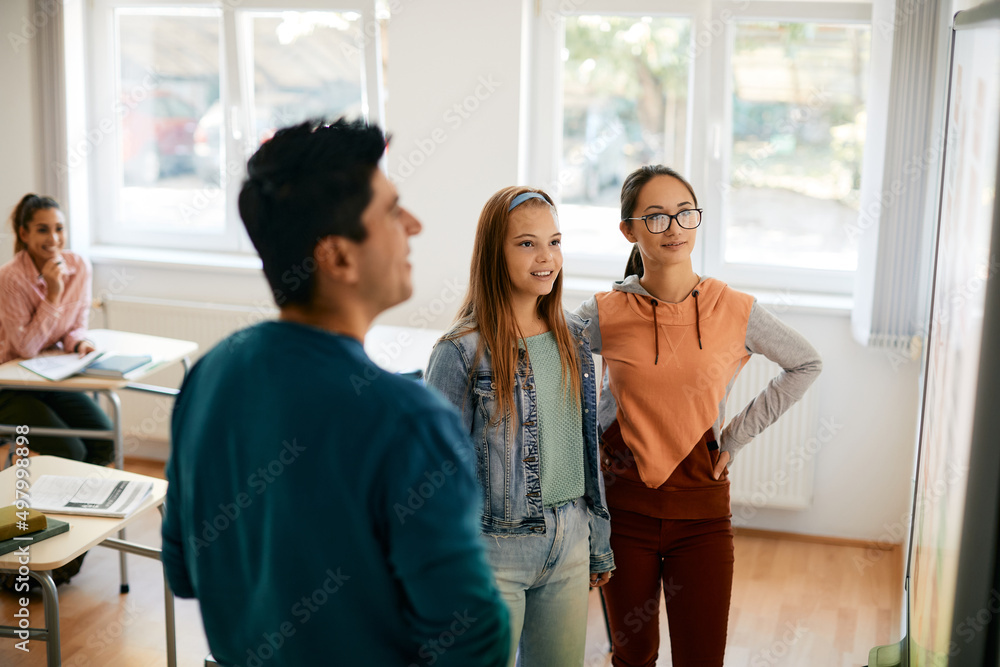 Teenage girls and their teacher in front of interactive whiteboard at ...