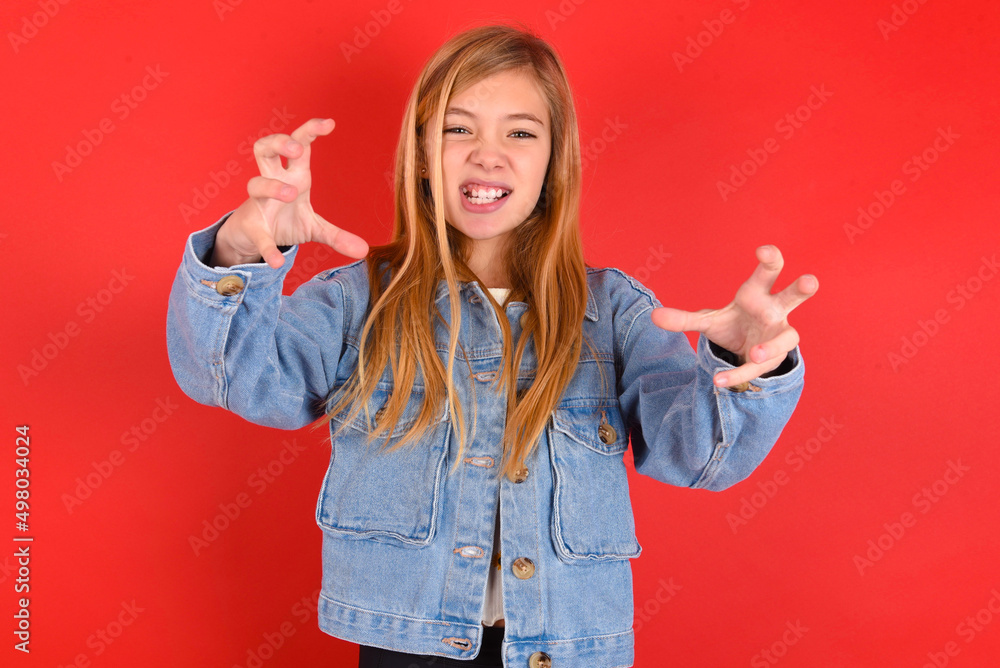 blonde little kid girl wearing denim jacket over red background ...