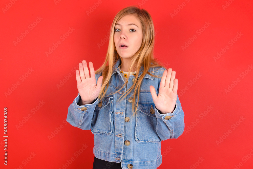blonde little kid girl wearing denim jacket over red background Moving ...