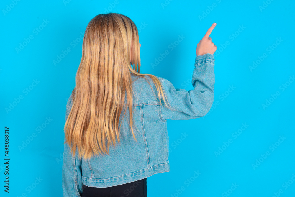 blonde little kid girl wearing denim jacket over blue background ...