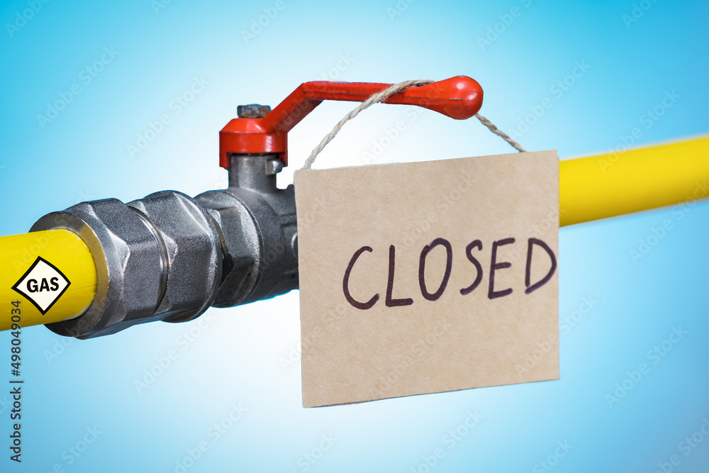 Stopping the gas supply. Gas valve and CLOSED label on blue background ...