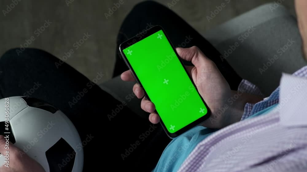 Football fan use smartphone at home with green chroma key Screen ...