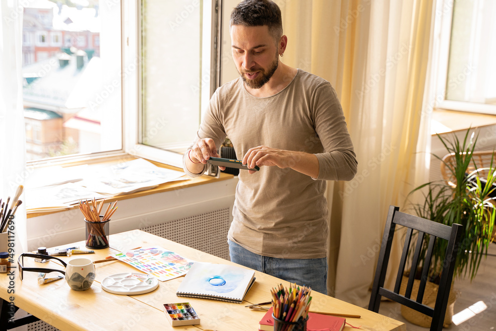 A creative person is in his studio. The artist creates digital content ...