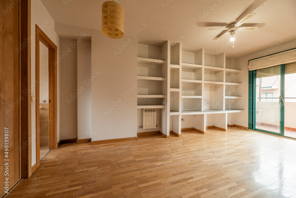 empty room with plaster shelf with glass shelves, aluminum radiators ...