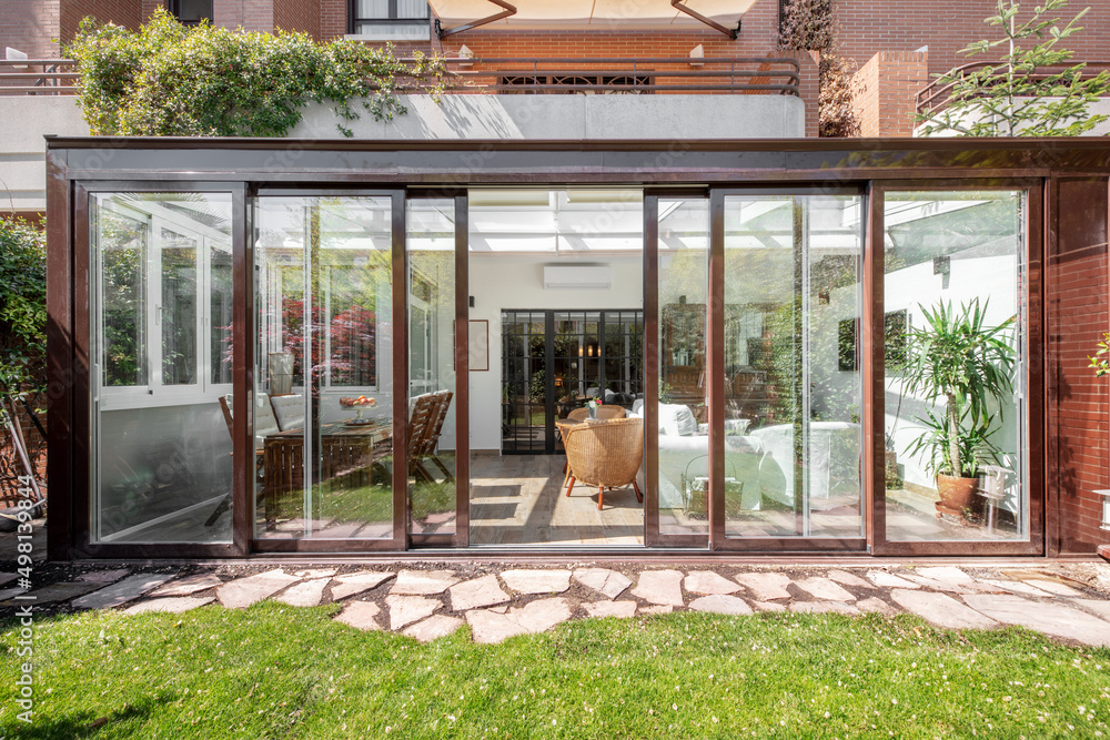 Glass and brown aluminum covered terrace at the bottom of a residential ...
