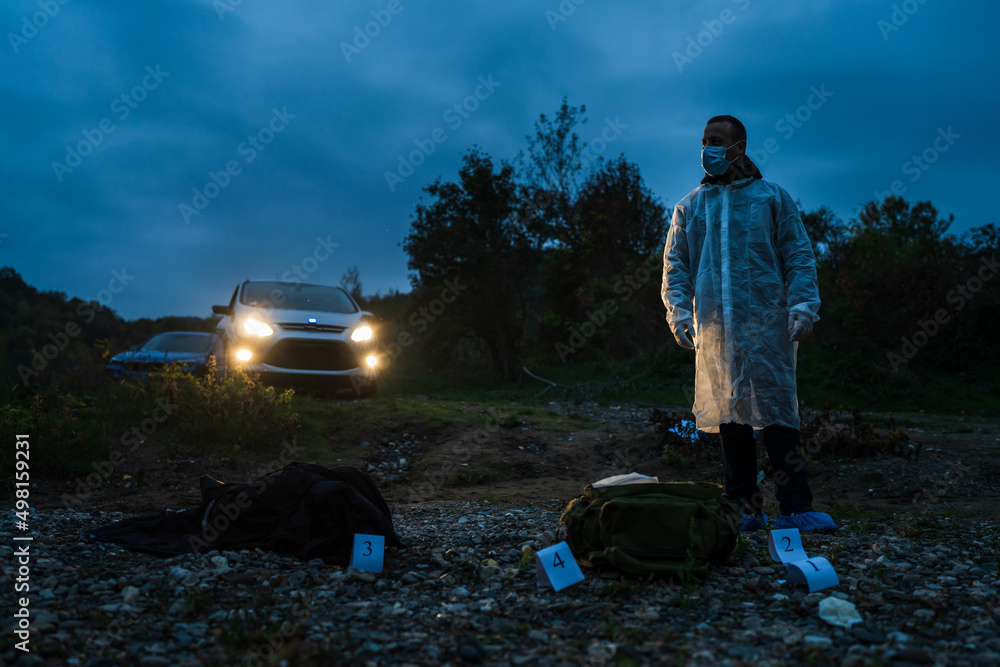 Forensic police investigator collecting evidence at the crime scene in ...