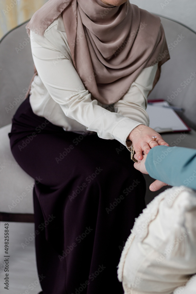 Portrait of a Muslim woman psychologist dressed in a beige hijab holds ...